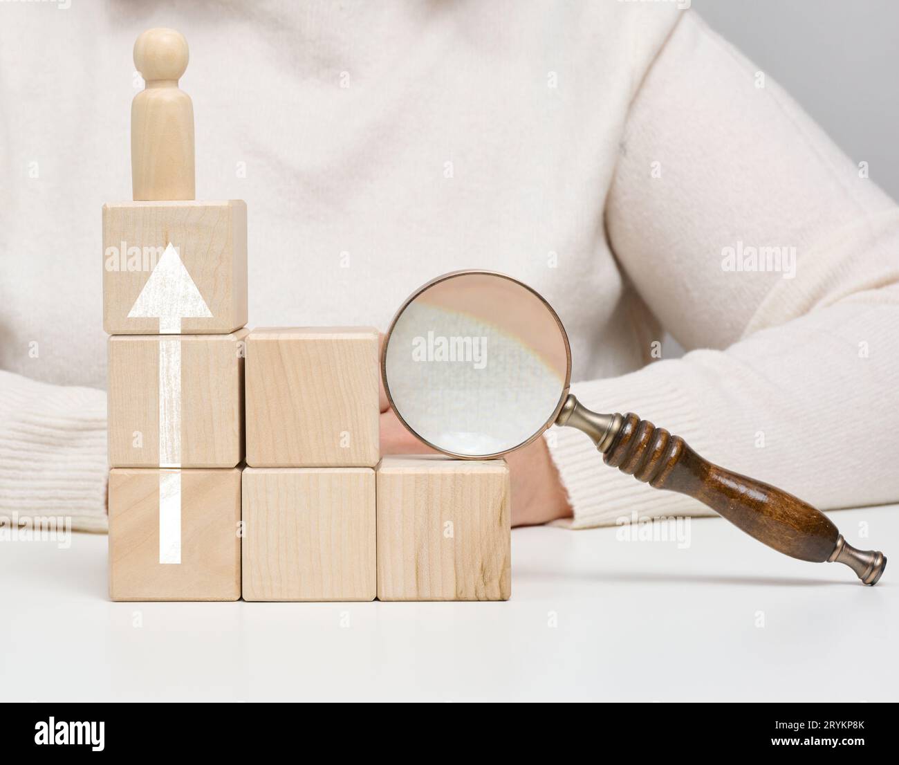 Magnifying glass and wooden men on a white table. Personnel recruitment ...