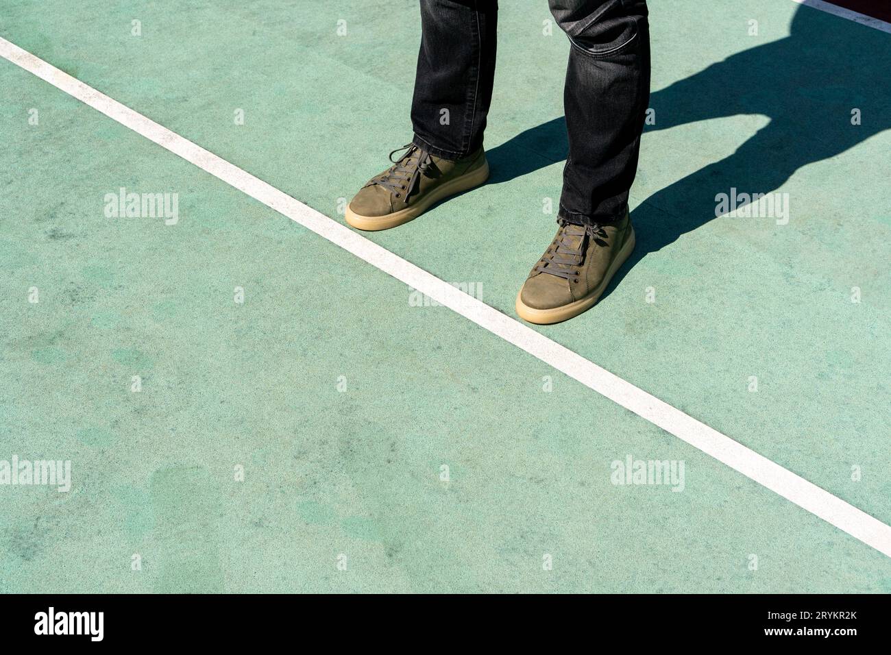 Man standing on rubberized ground with white race line, beginning idea ...