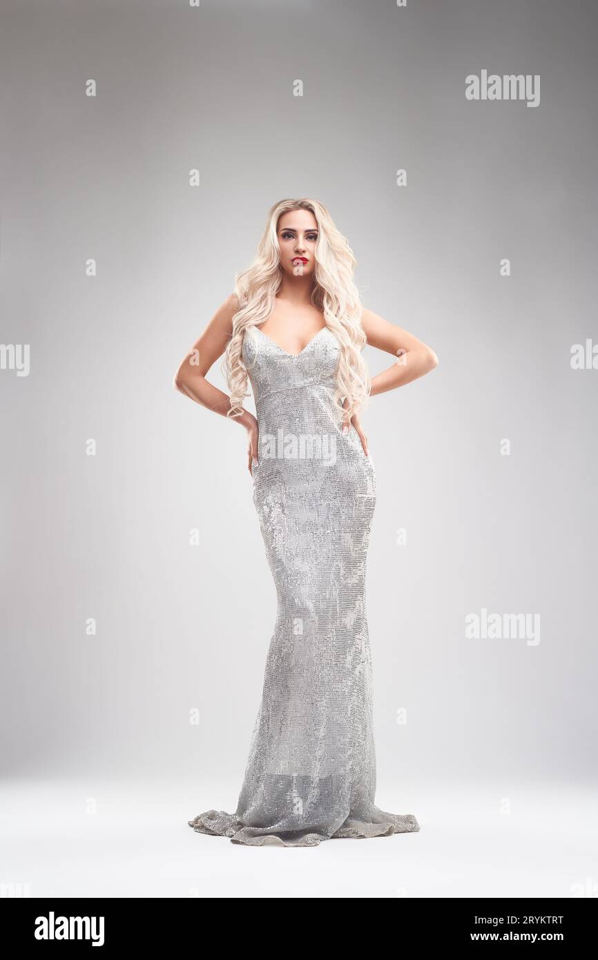 Full body of attractive blond woman in stylish dress looking at camera ...