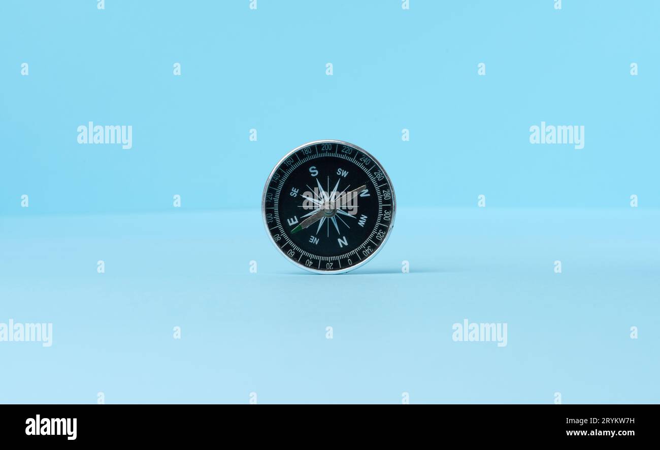 Round compass on a blue background Stock Photo - Alamy