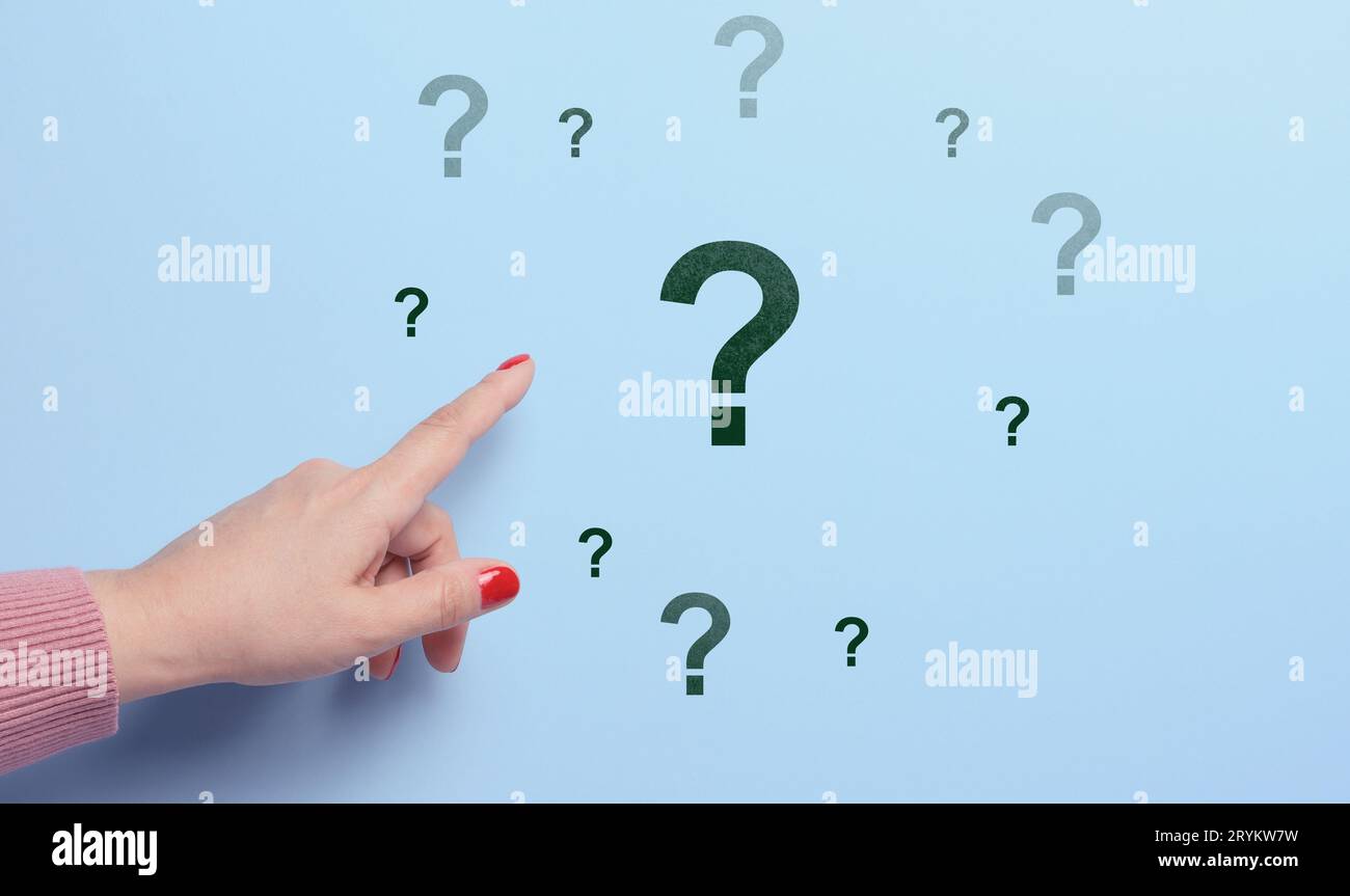 Woman's hand pointing to a question mark on a blue background Stock ...