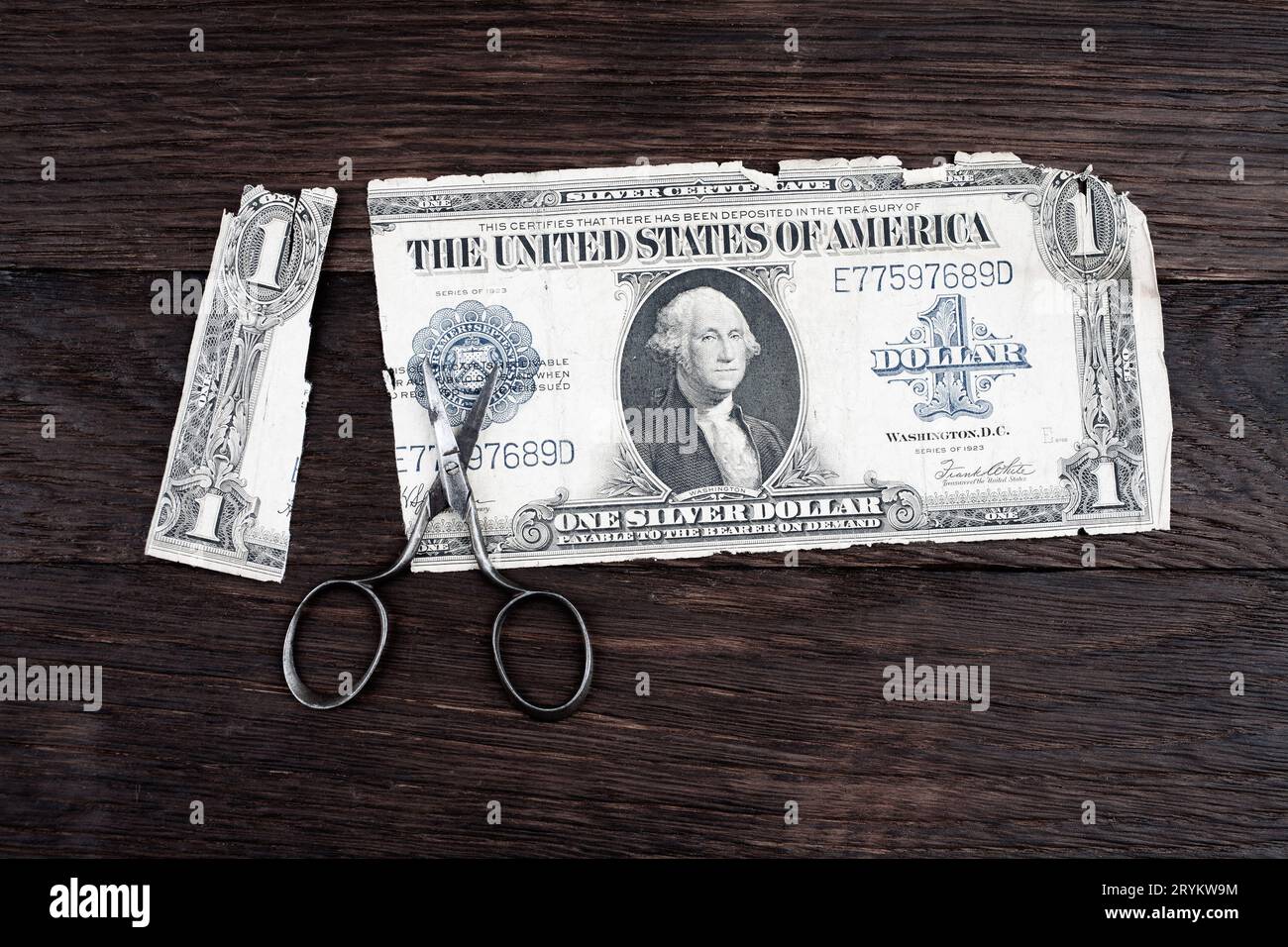 Vintage embroidery scissors cutting old paper dollar bill on wooden ...