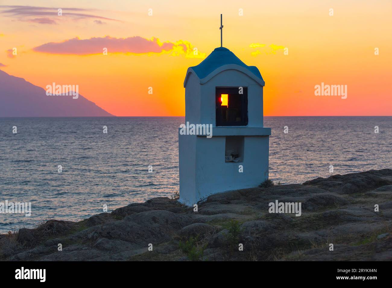Small greek chapel and mount Athos at sunrise or sunset with sea ...