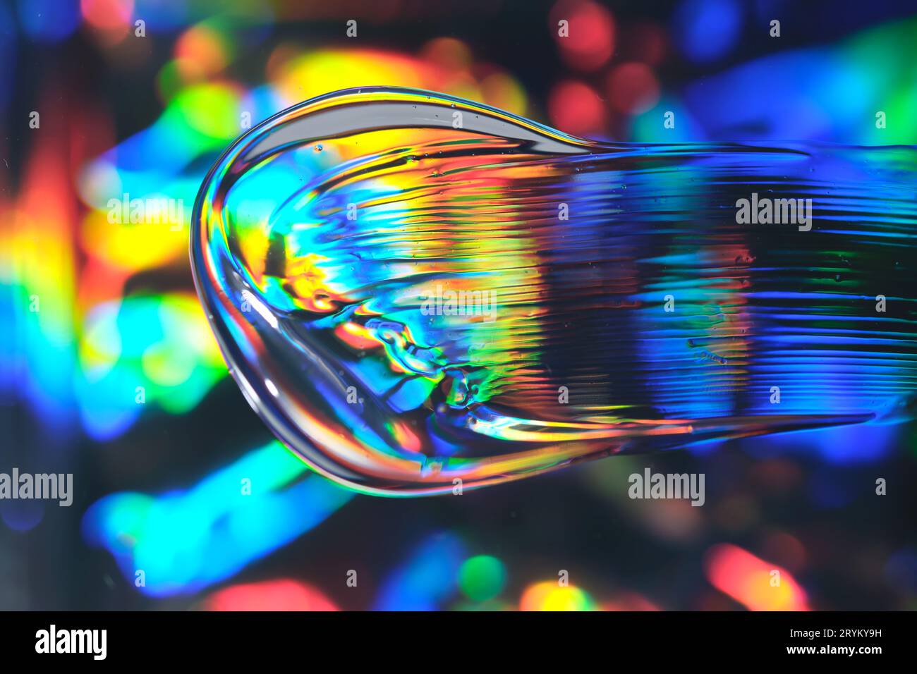 Drop of cosmetic transparent gel on a halographic background. The ...