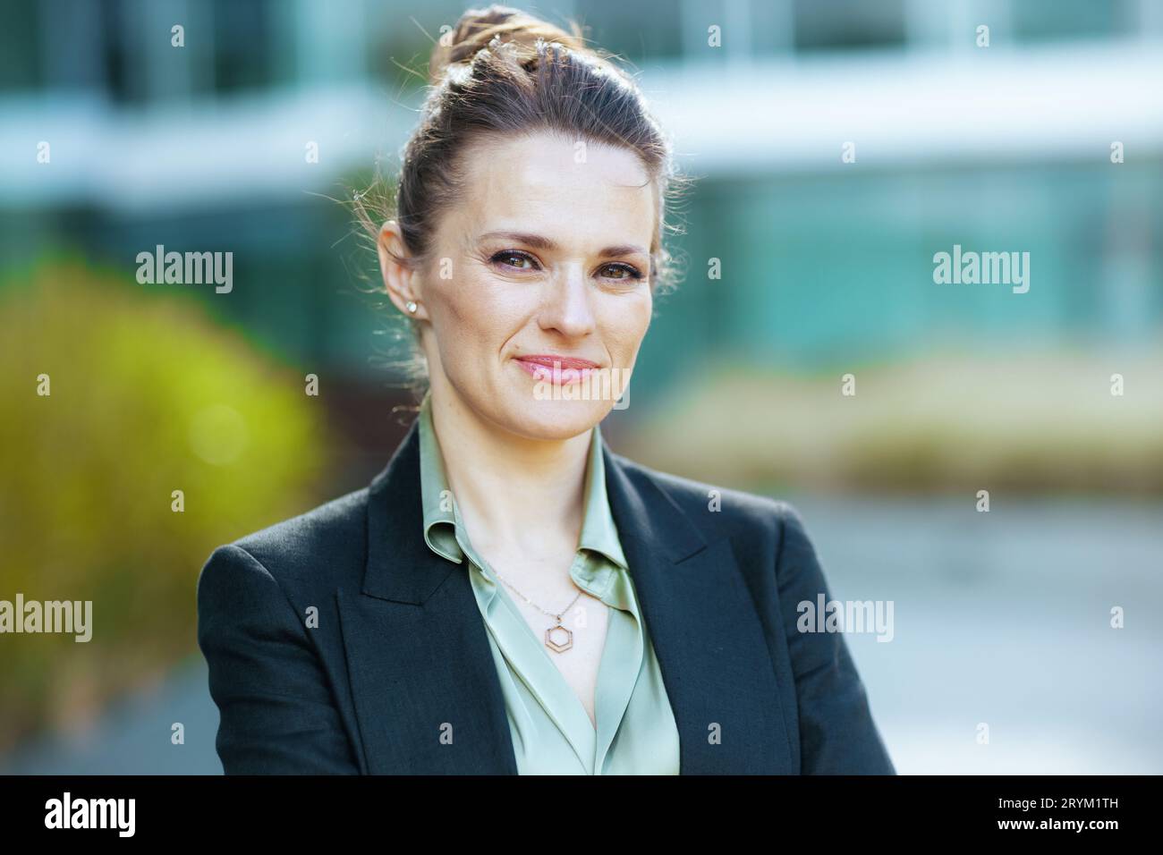 Portrait of sad modern 40 years old woman employee near office building ...