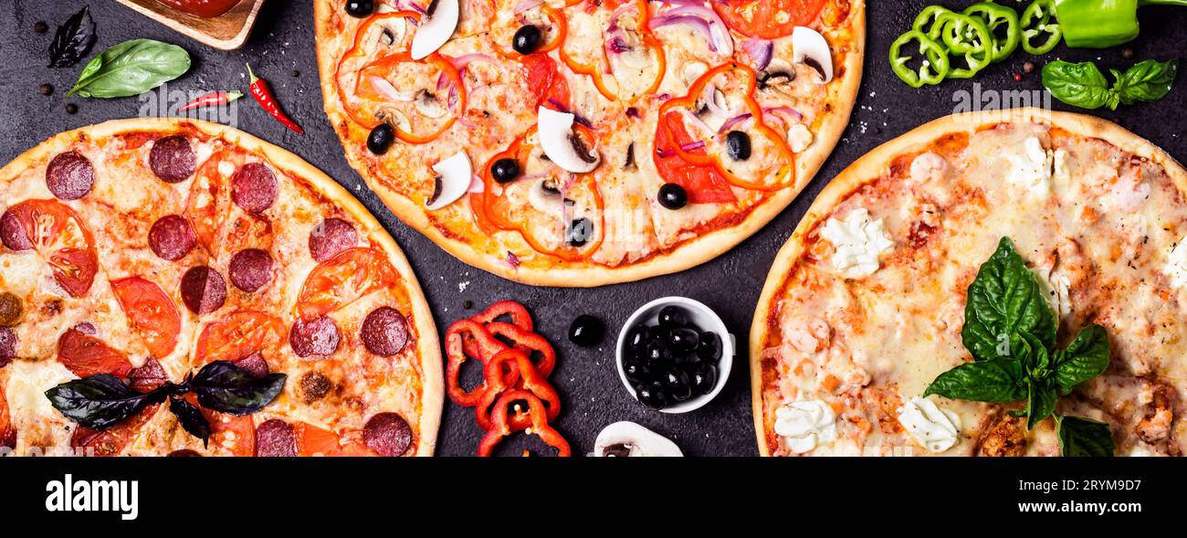 Selection of different pizzas on a black background and ingredients ...