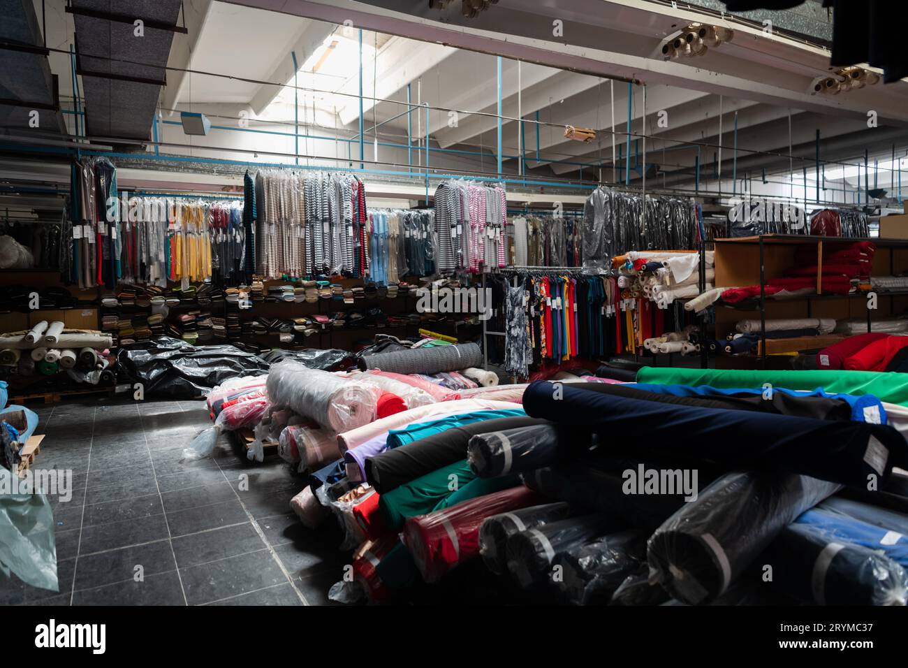 Interior of an industrial warehouse with fabric rolls samples. Small ...