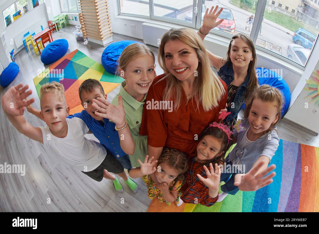 Children in a preschool institution standing in the classroom together ...