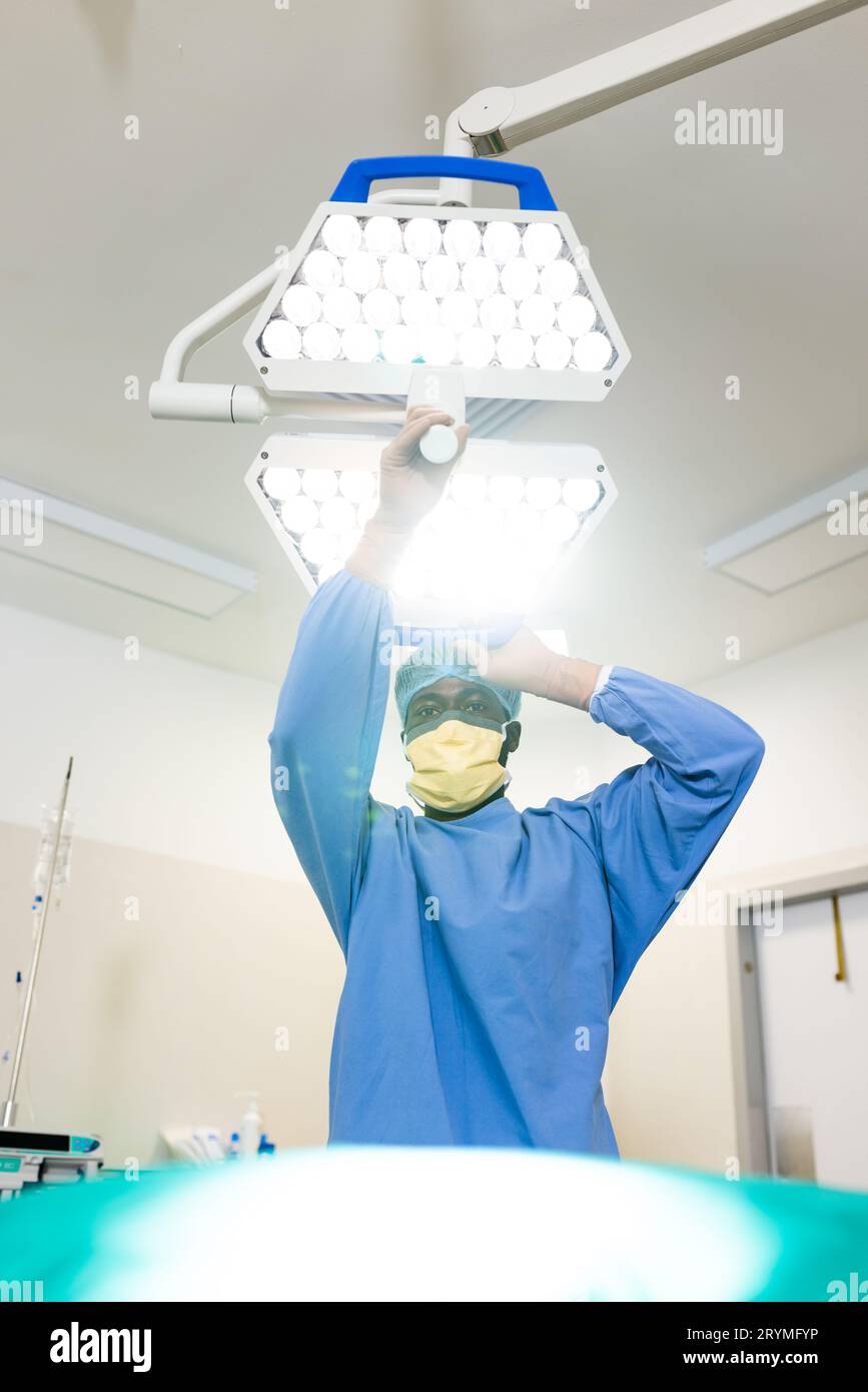 African american male surgeon adjusting light before operation in ...
