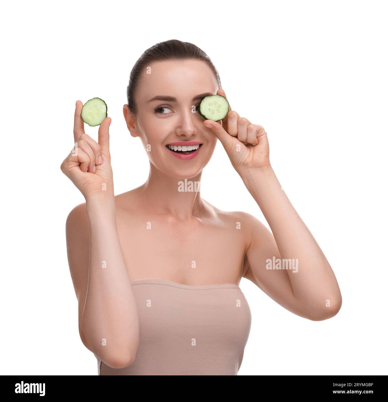 Beautiful woman covering eye with piece of cucumber on white background ...