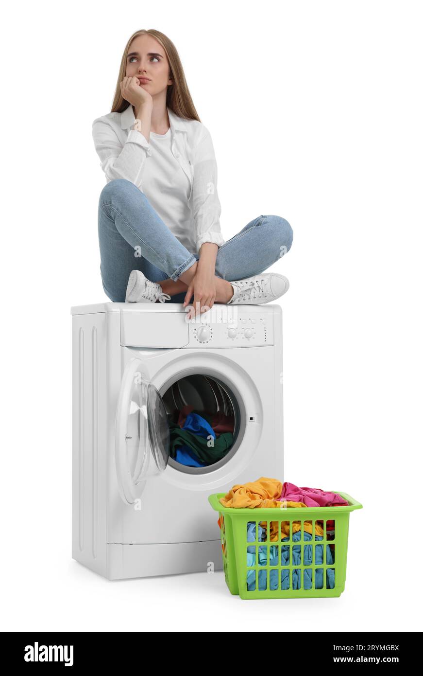 Upset woman on washing machine with laundry against white background ...