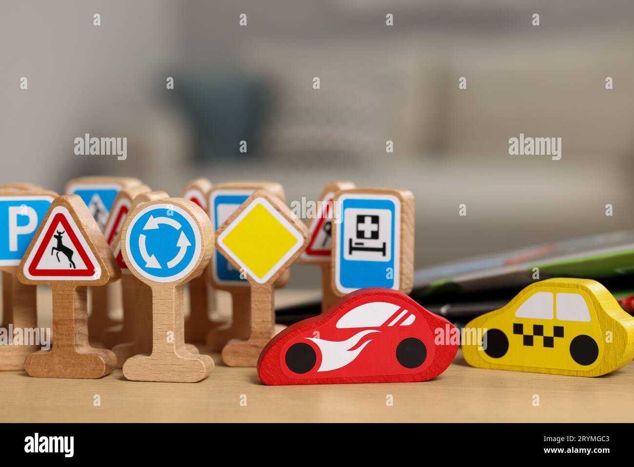 Set of wooden road signs and cars on table indoors, closeup. Children's ...