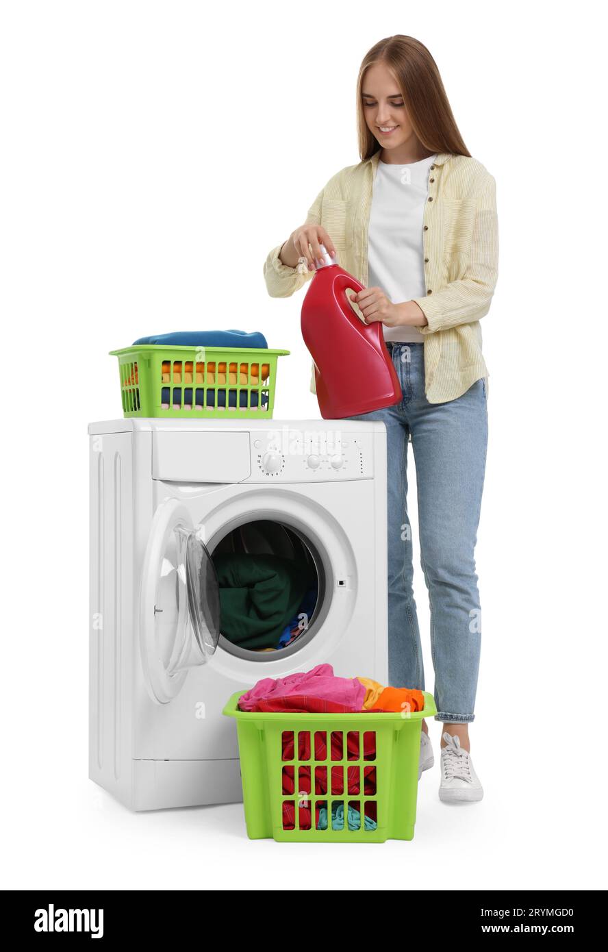 Beautiful young woman with detergent and laundry near washing machine on white background Stock ...