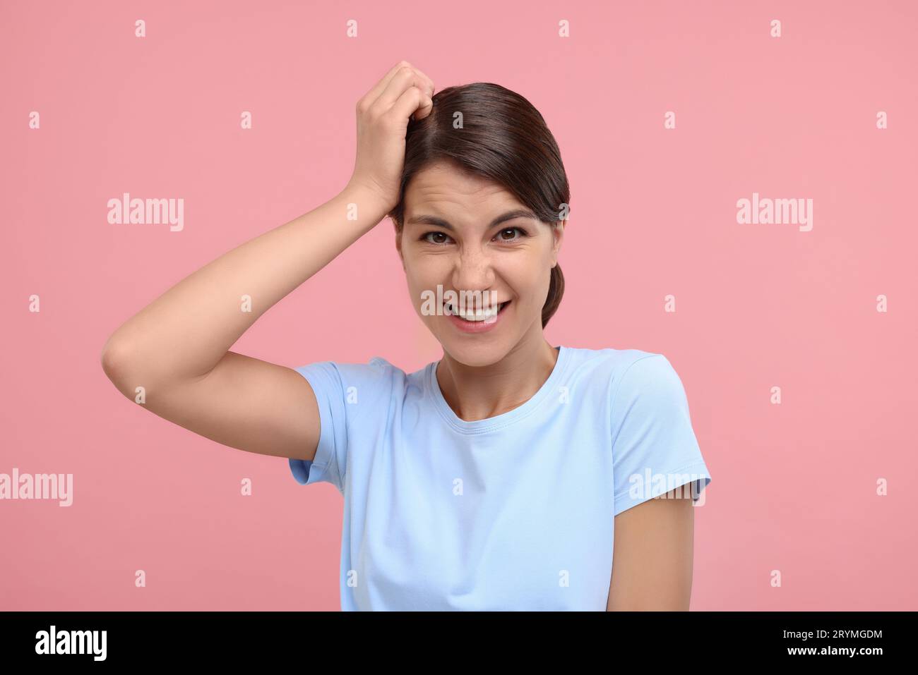 Portrait of embarrassed young woman on pink background Stock Photo - Alamy
