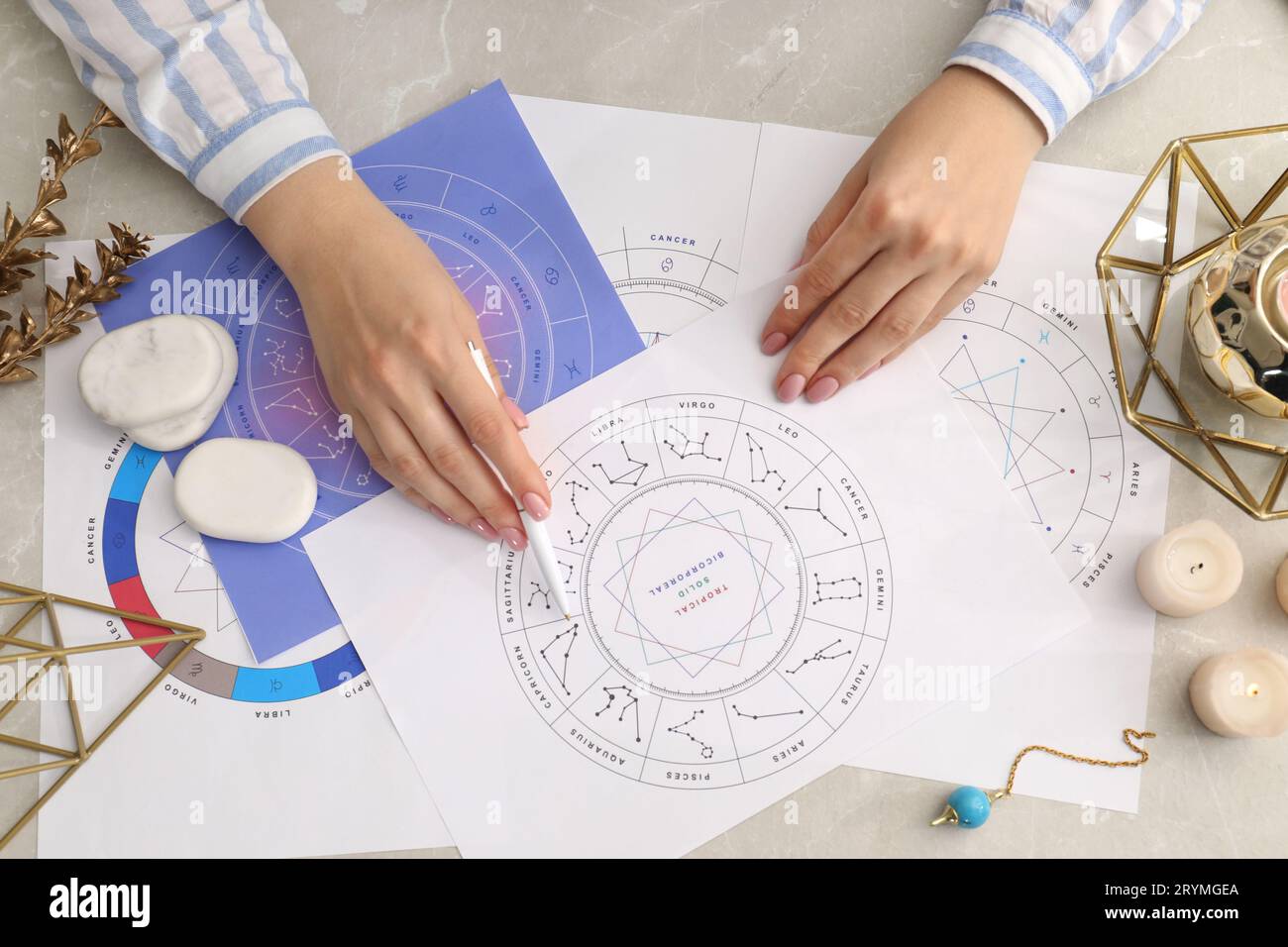 Astrologer using zodiac wheel for fate forecast at table, top view ...