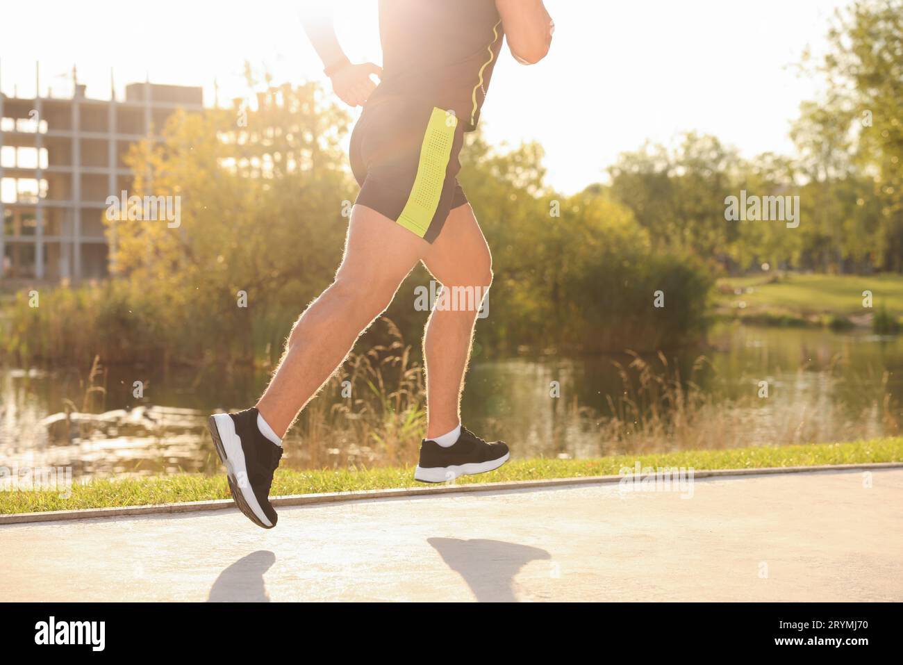 Man running near pond in park, closeup Stock Photo - Alamy