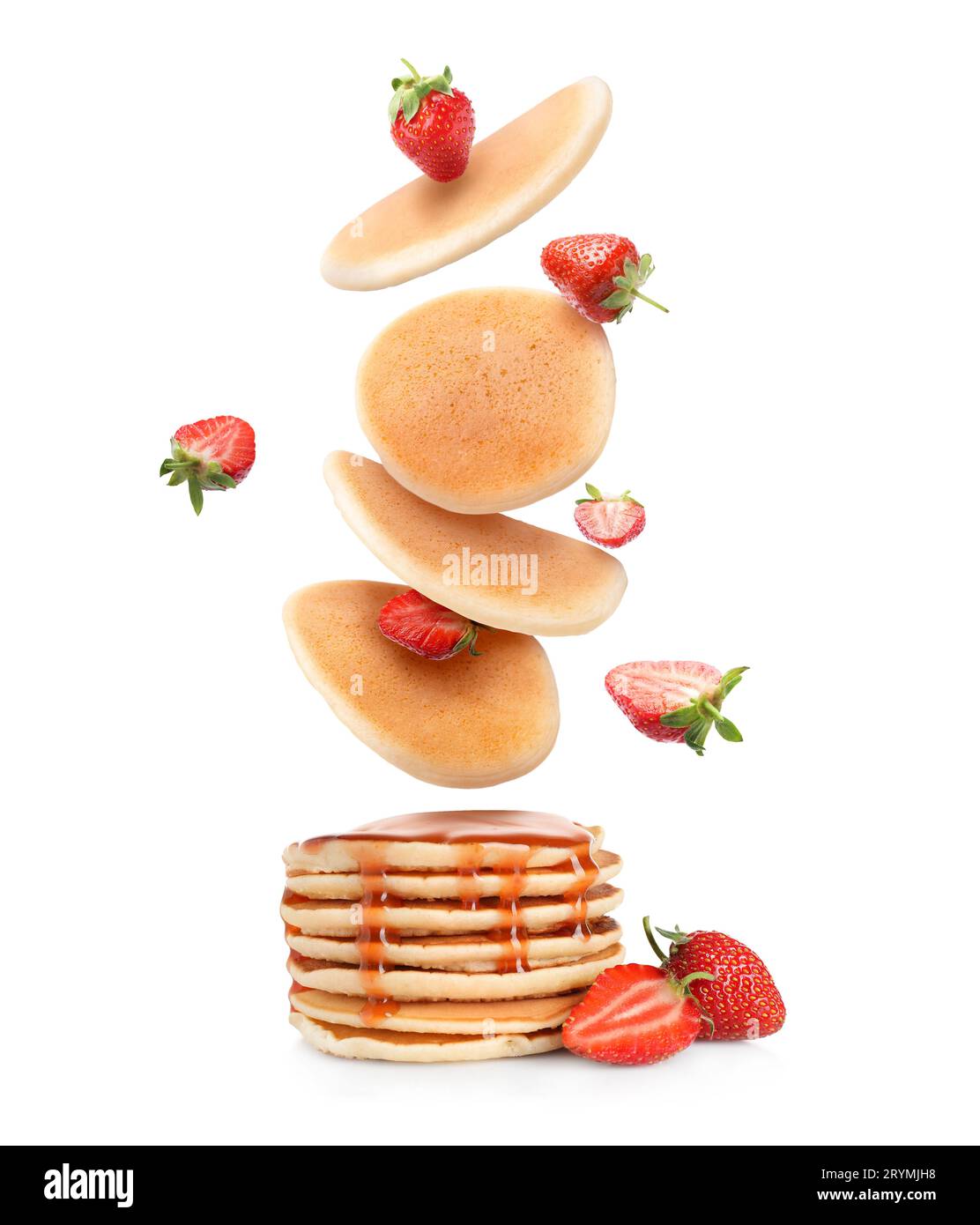 Many fresh pancakes and strawberries falling onto stack against white ...