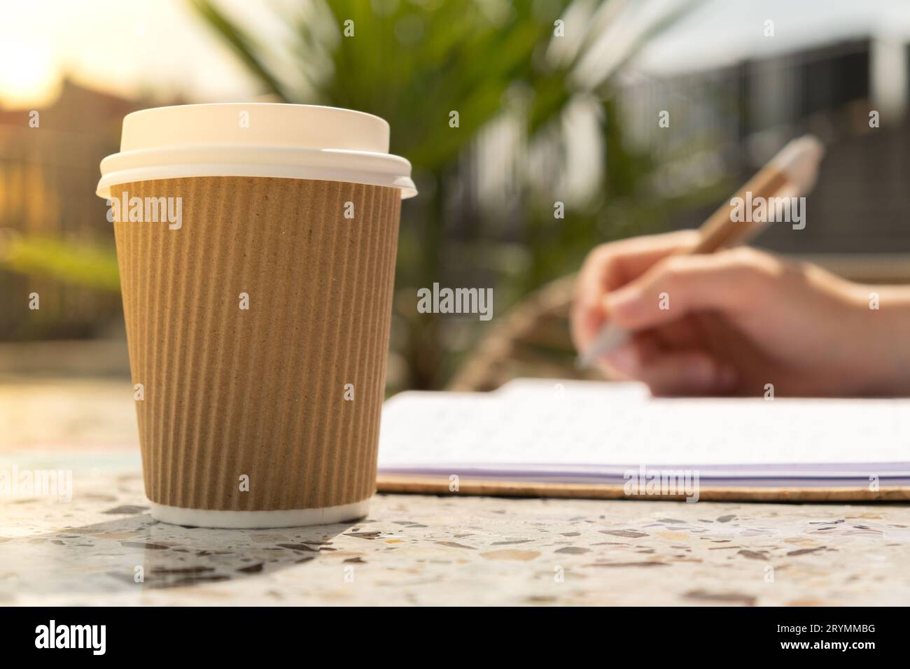 Unrecognizable Young woman study in beach resort. Drinking coffee from ...