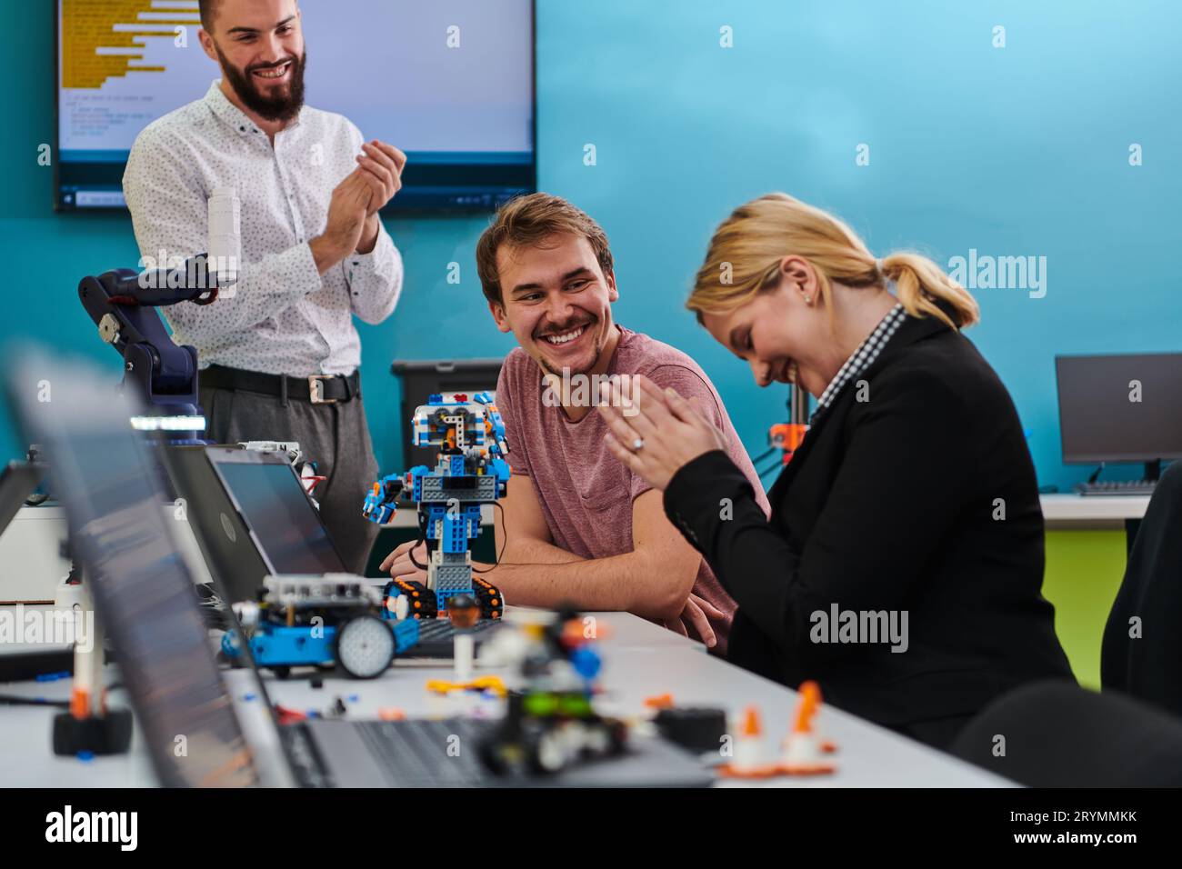 A Group Of Colleagues Working Together In A Robotics Laboratory Focusing On The Intricate