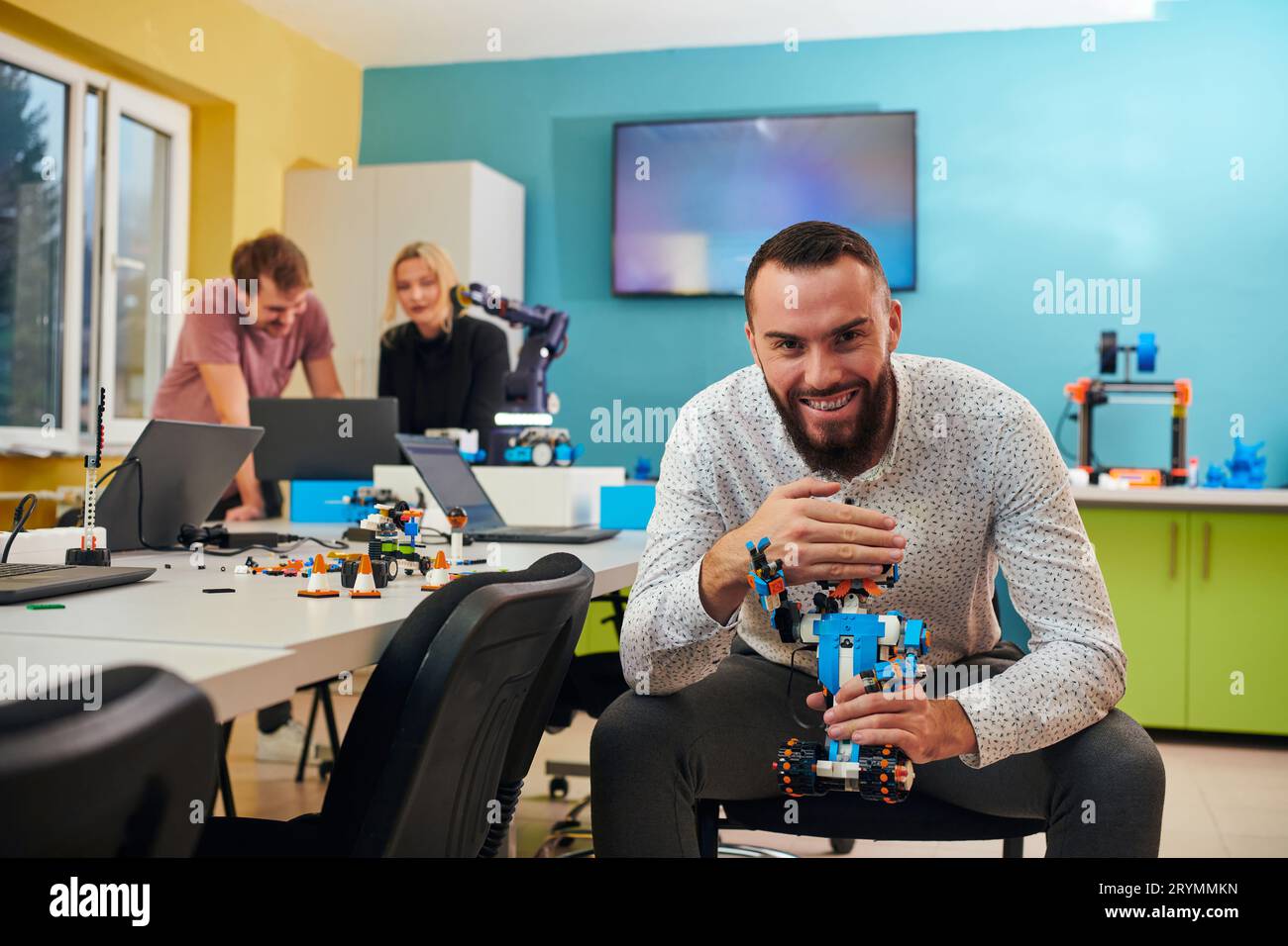 A group of colleagues working together in a robotics laboratory ...