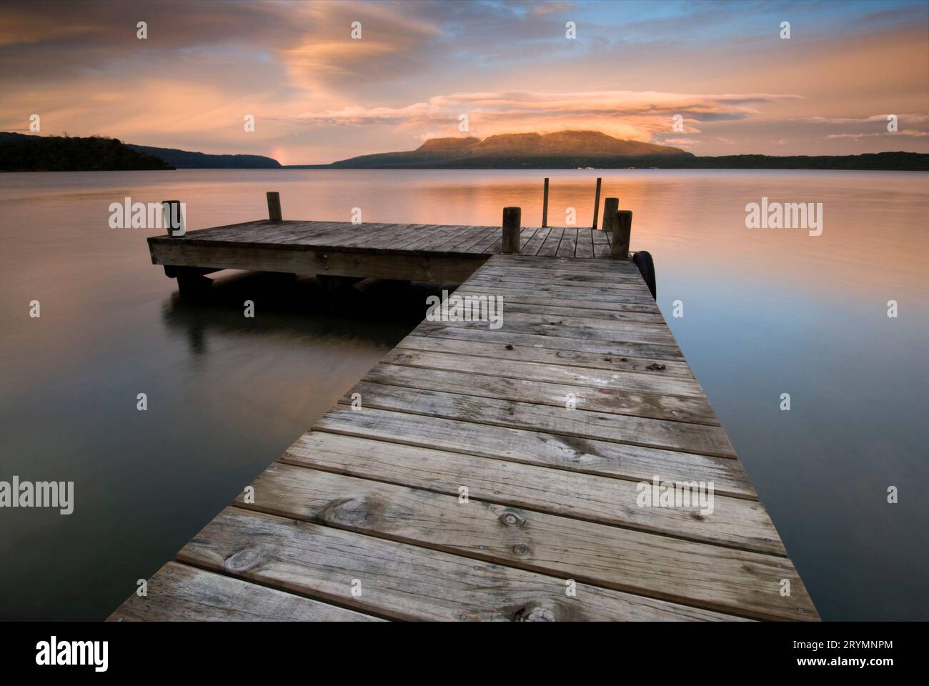 Suns last rays on Mt Tarawera with boat jetty in foreground. Sunset ...