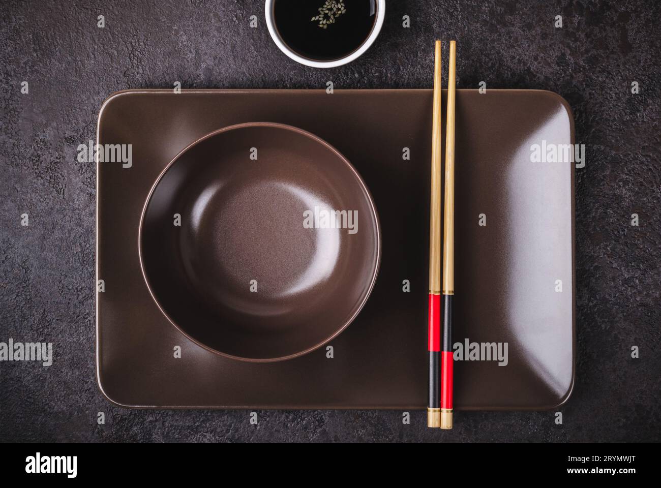 Asian table setting. Brown bowls, soy sauce and bamboo chopsticks Stock ...