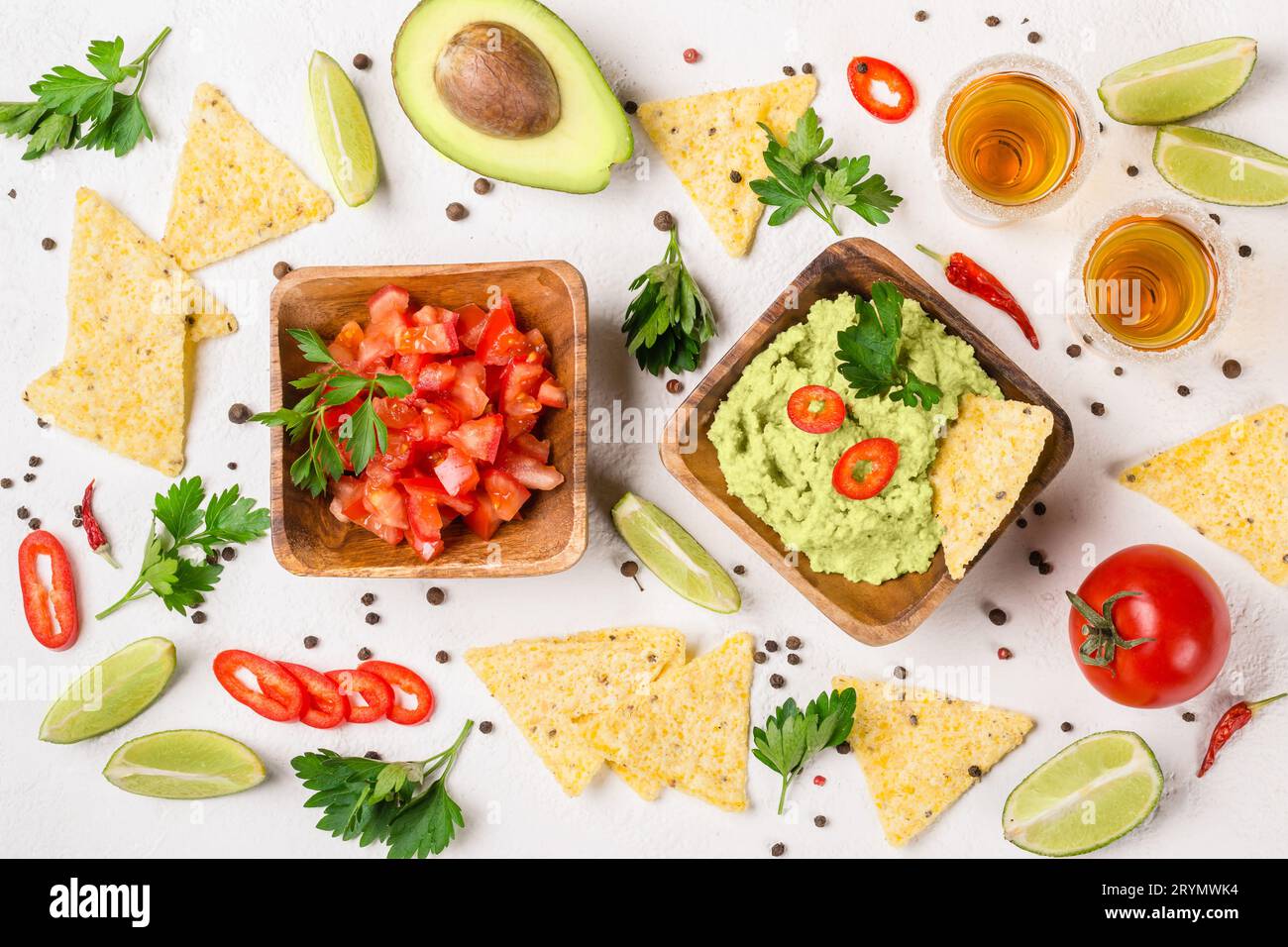 Mexican food party selection: sauce guacamole, salsa, chips and tequila ...
