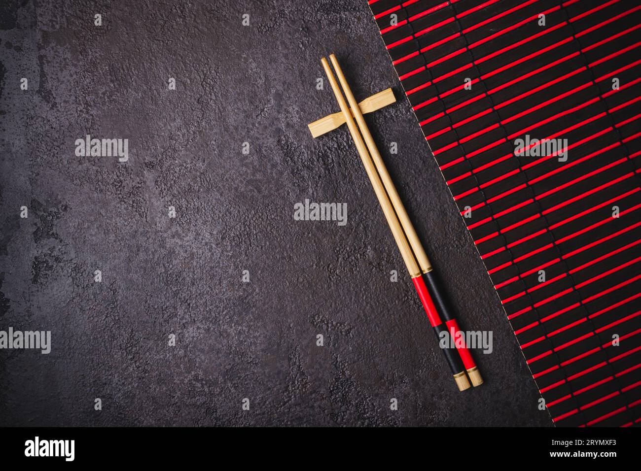 Asian Japanese table setting. Bamboo chopsticks and red black mat on ...