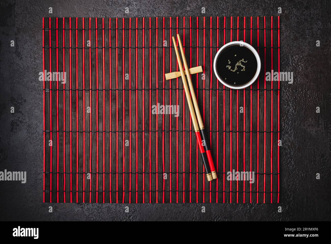 Japanese table setting. Bamboo chopsticks and soy sauce bowl on striped ...