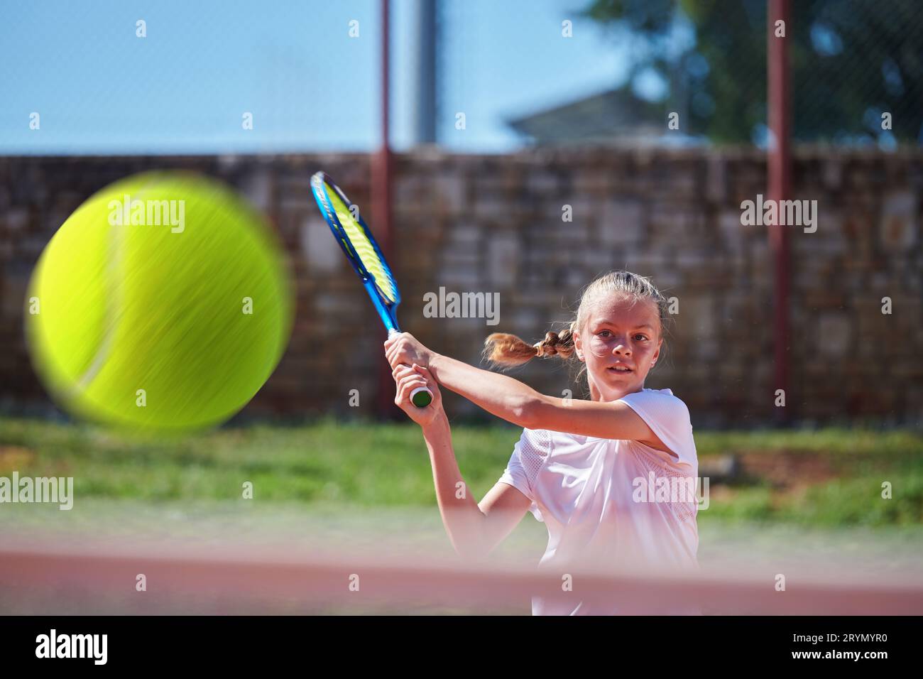 A young girl showing professional tennis skills in a competitive match ...