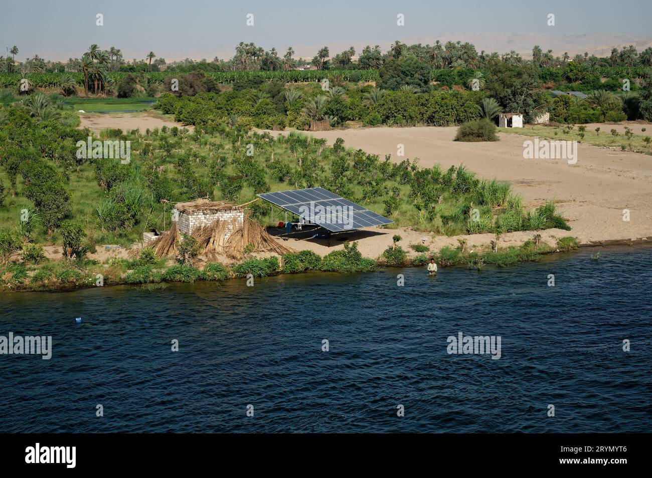 Majestic nile energy: a large solar panel and a shack near the river ...