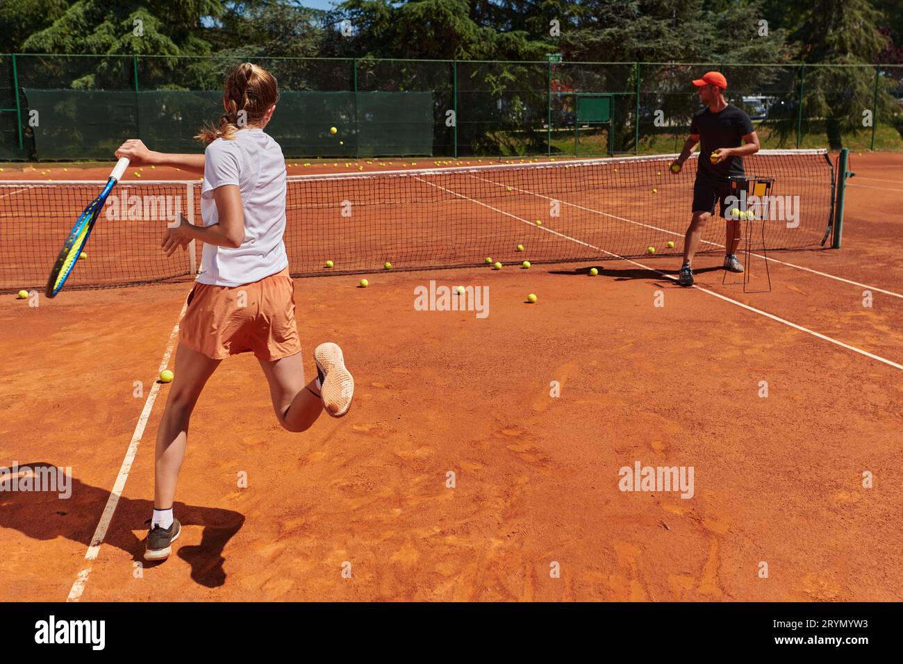 A professional tennis player and her coach training on a sunny day at ...