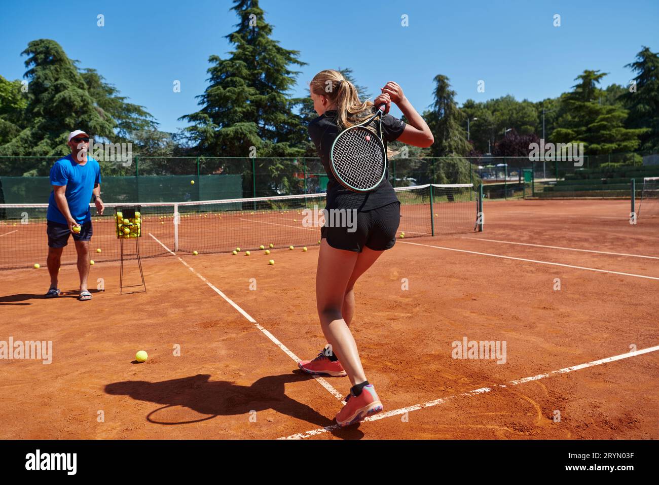 A professional tennis player and her coach training on a sunny day at ...