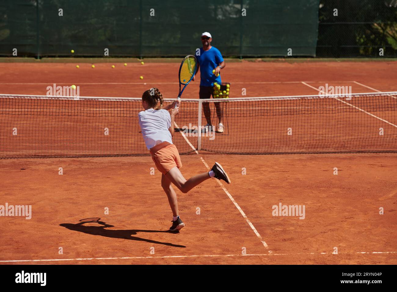 A professional tennis player and her coach training on a sunny day at ...