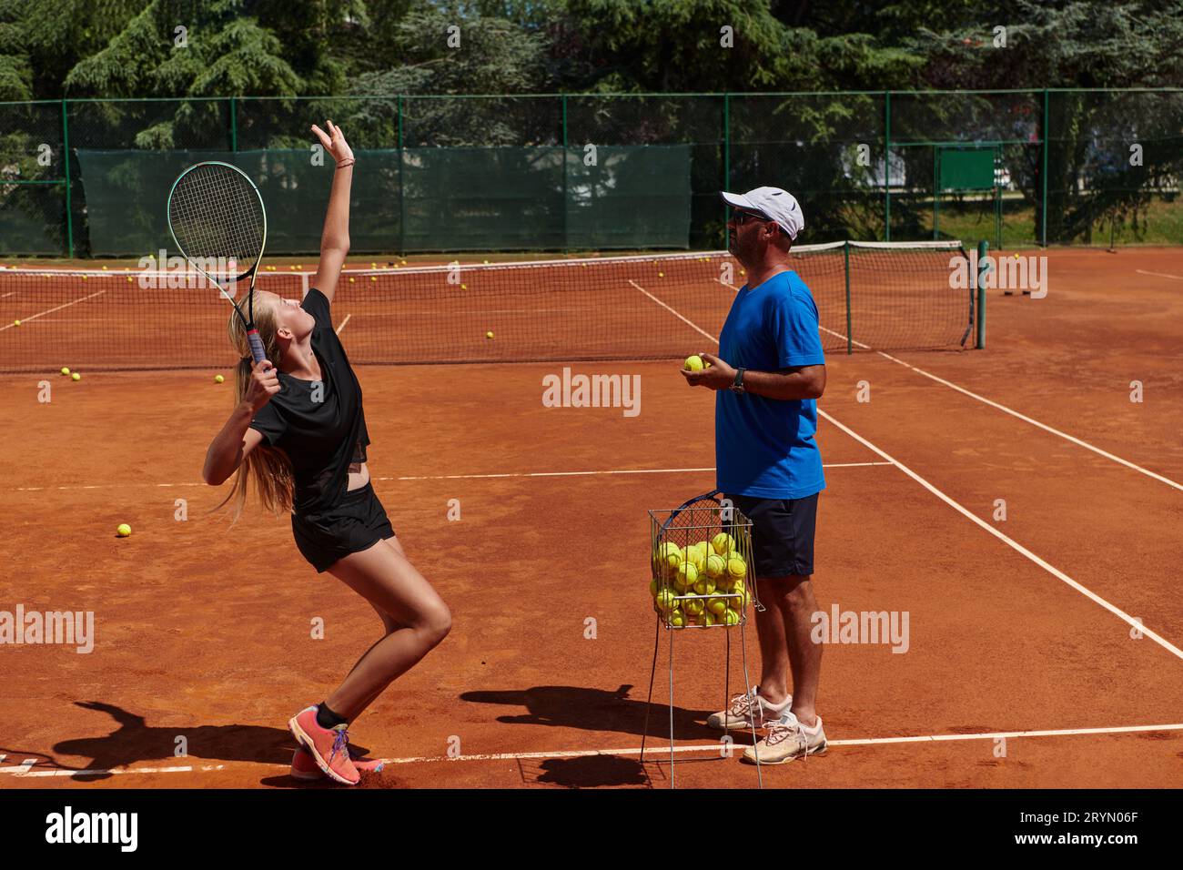 A professional tennis player and her coach training on a sunny day at ...