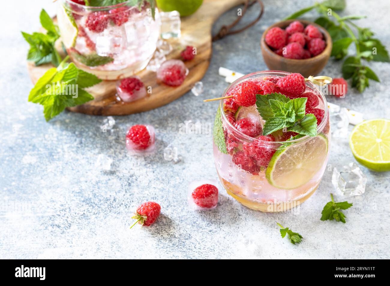 Hard seltzer cocktail with raspberries and lime on a gray stone table top. Copy space Stock ...