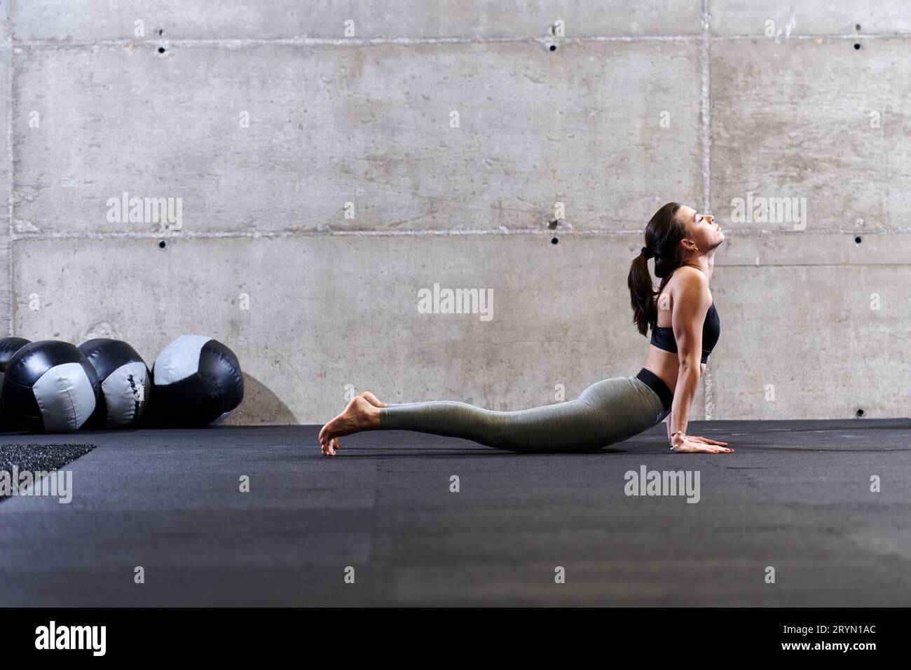 Fit woman in a modern gym working flexibility and strength through ...