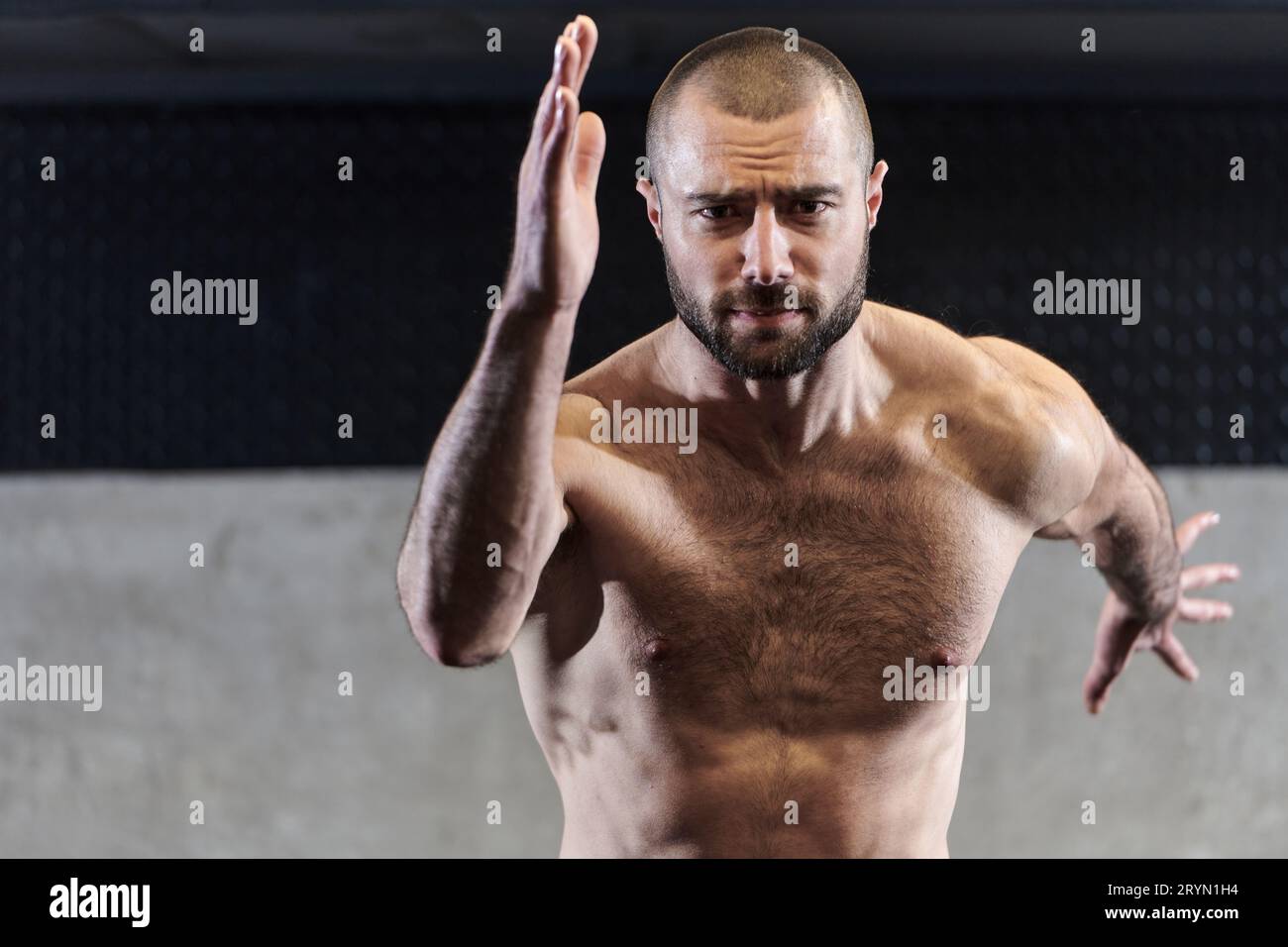 A muscular man standing in the starting position for running, exuding ...