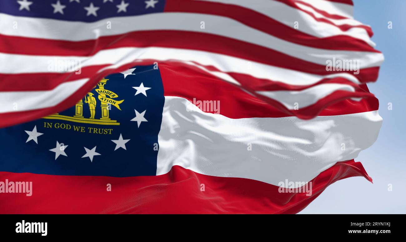 The flags of Georgia and United States waving in the wind on a clear ...