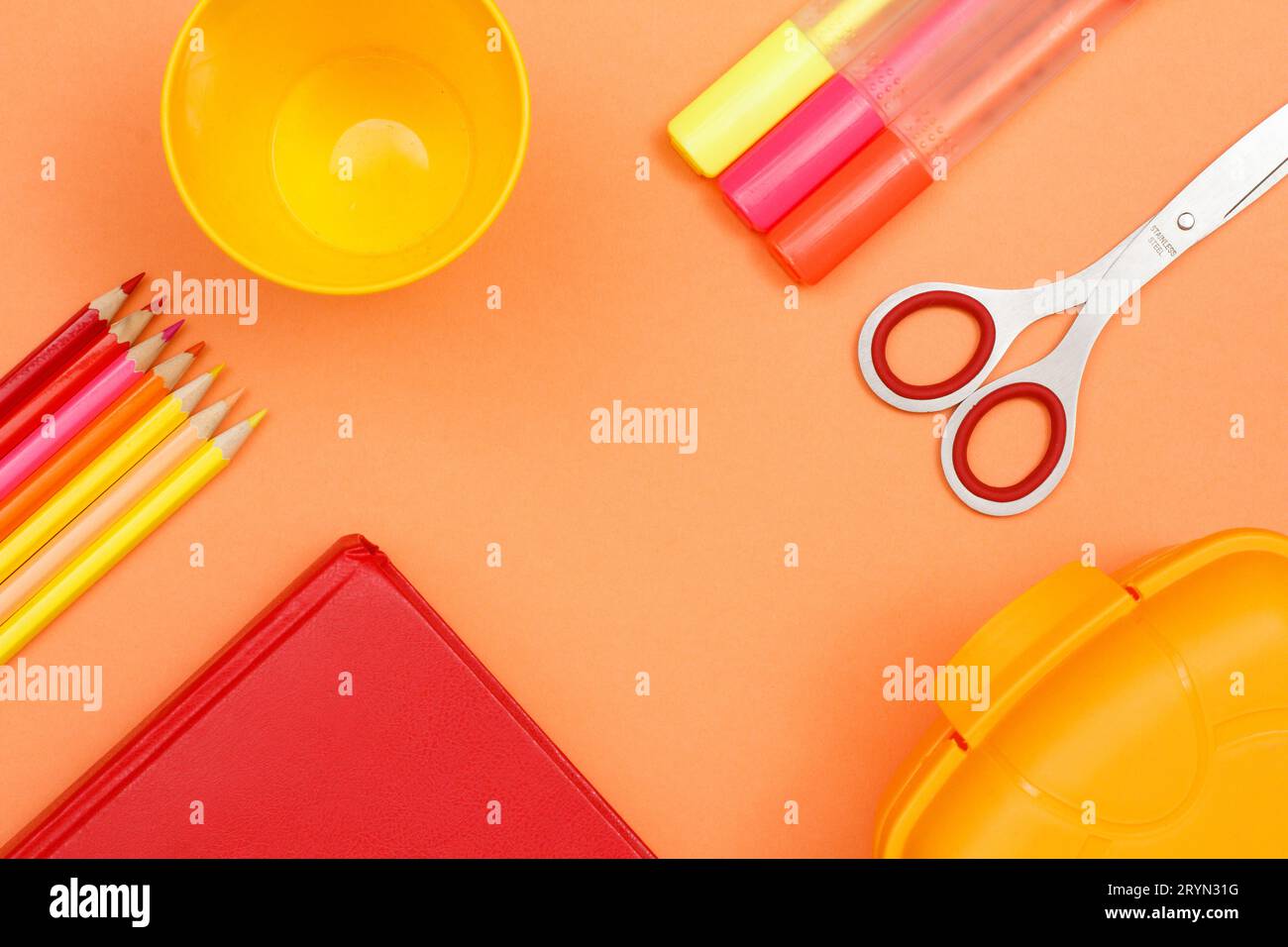 School supplies. Color pencils, a book, a plastic cup, felt pens, a ...