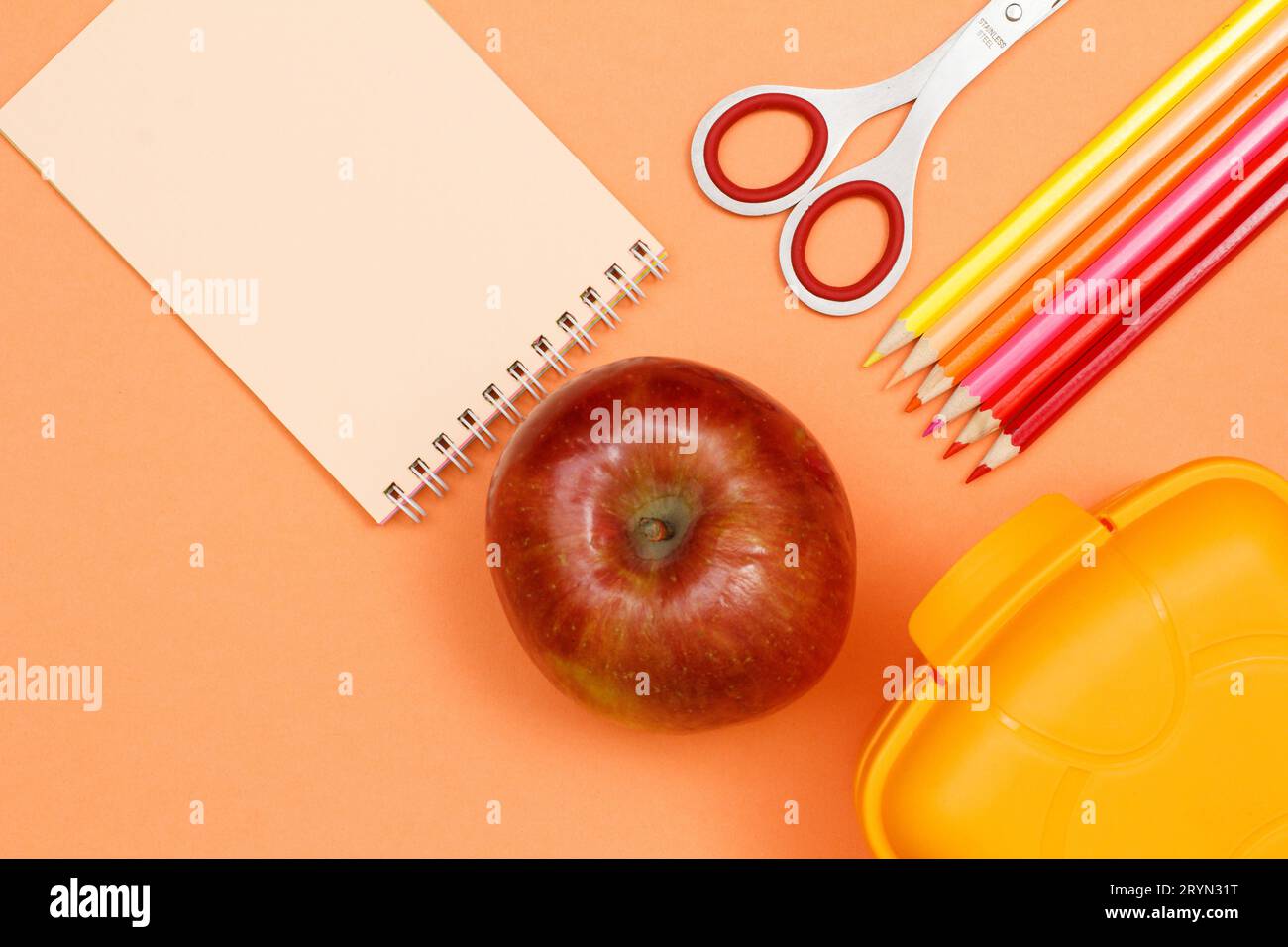 Notebook, an apple, a scissors, color pencils and a lunch box. School ...