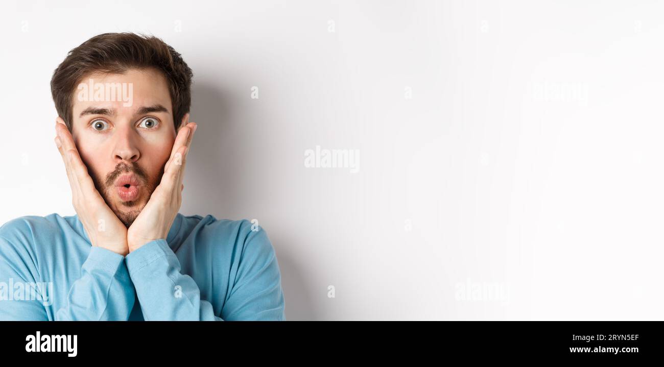 Close-up of impressed man checking out special offer, saying wow and ...