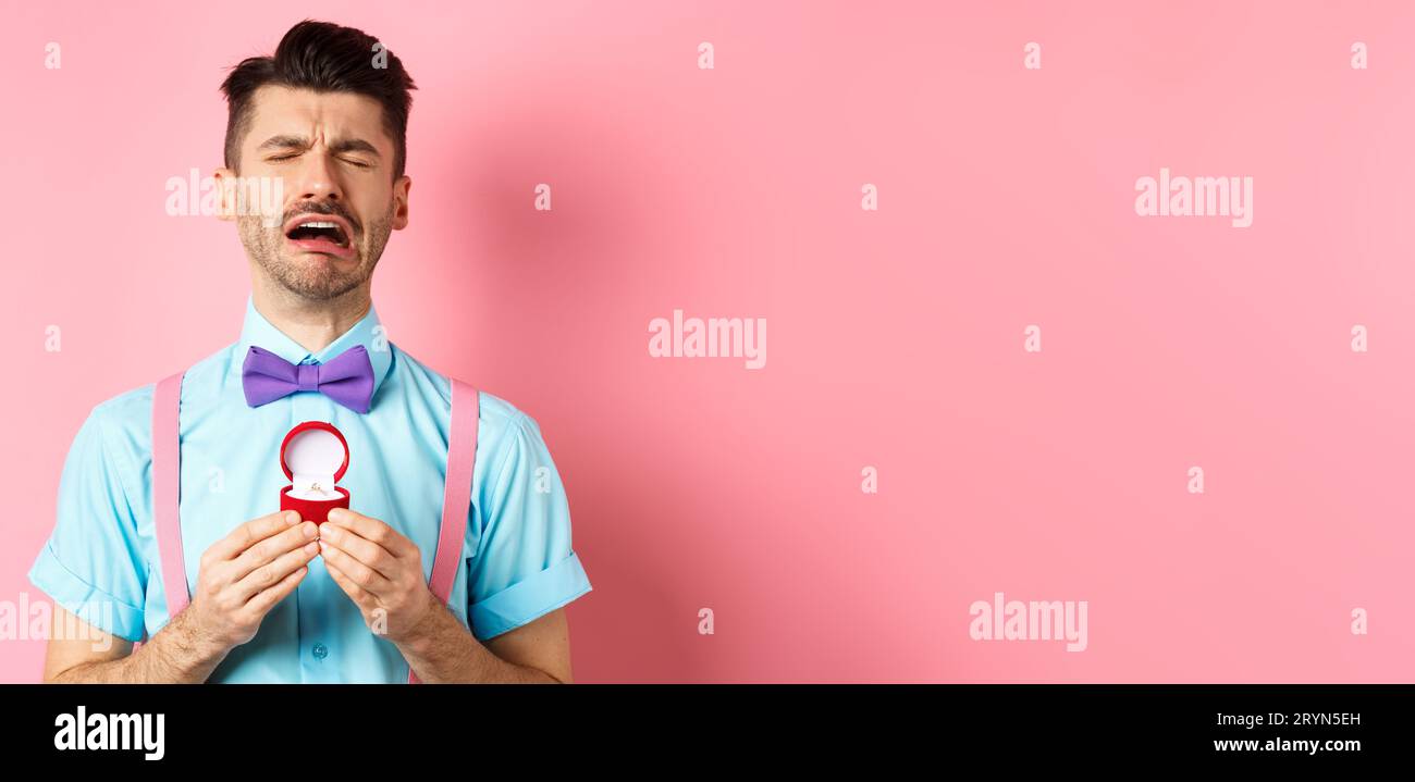 Valentines day. Heartbroken guy crying and holding engagement ring ...