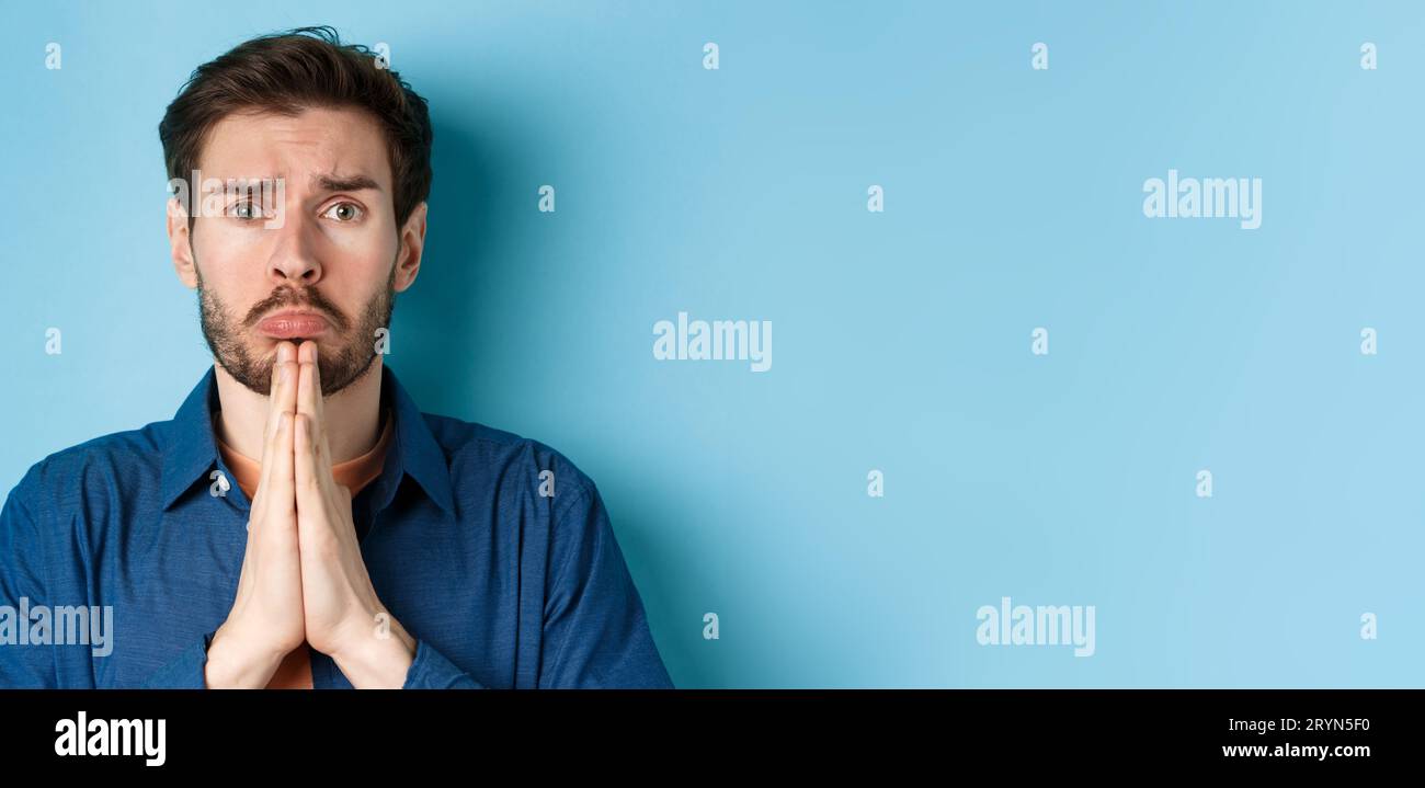 Sad young man begging for help, apoligizing and sobbing miserable ...