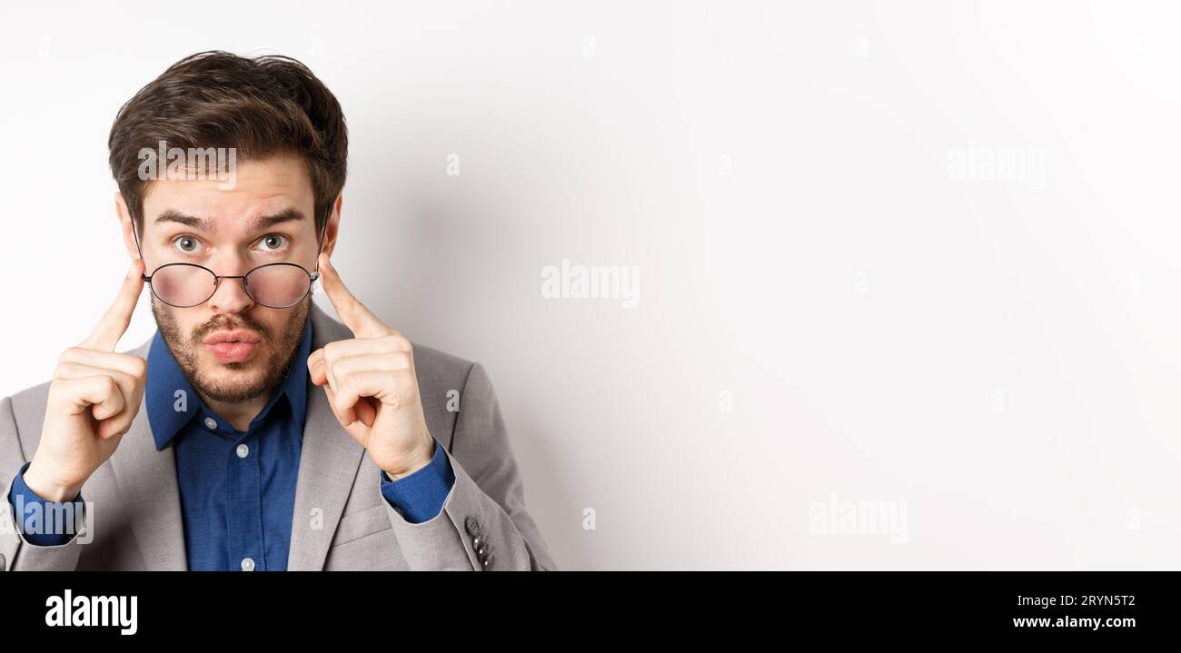 Surprised businessman takes-off glasses and look excited at camera ...