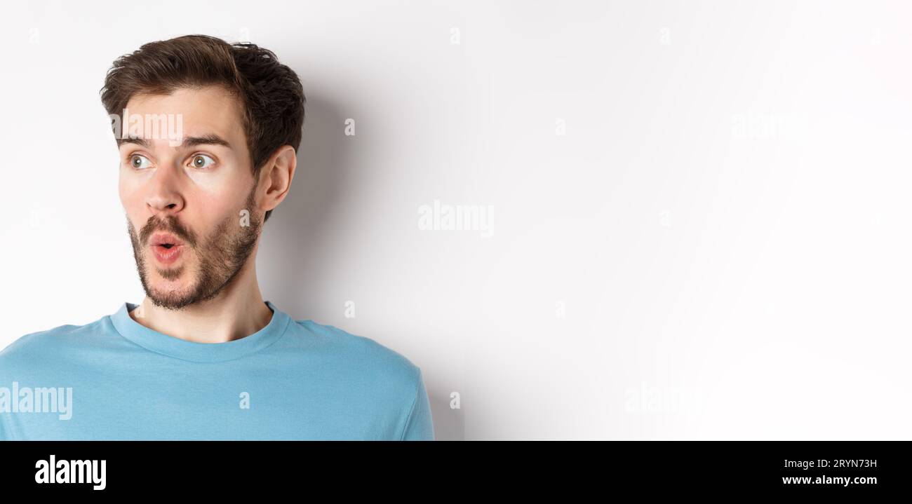 Close-up of impressed caucasian man saying wow, looking left amazed ...