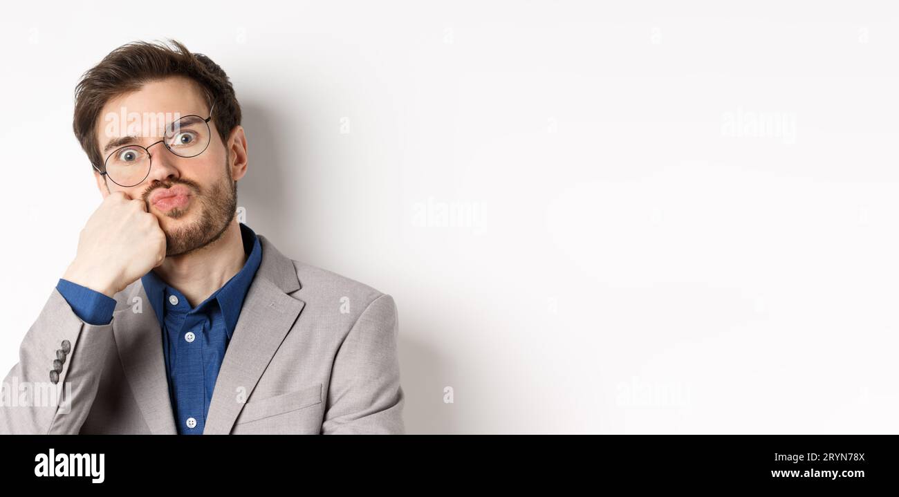 Bored funny office worker in glasses, pouting and holding breath ...