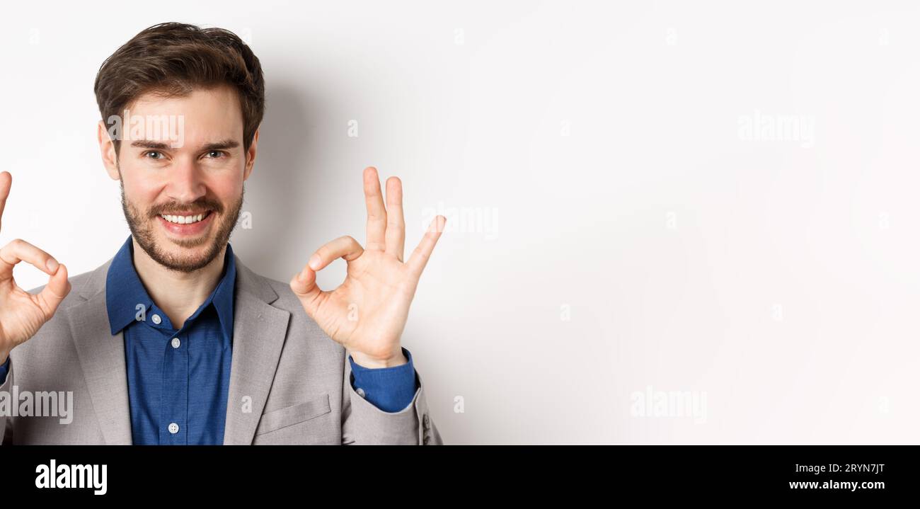 Smiling businessman in suit showing okay signs in approval, guarantee ...