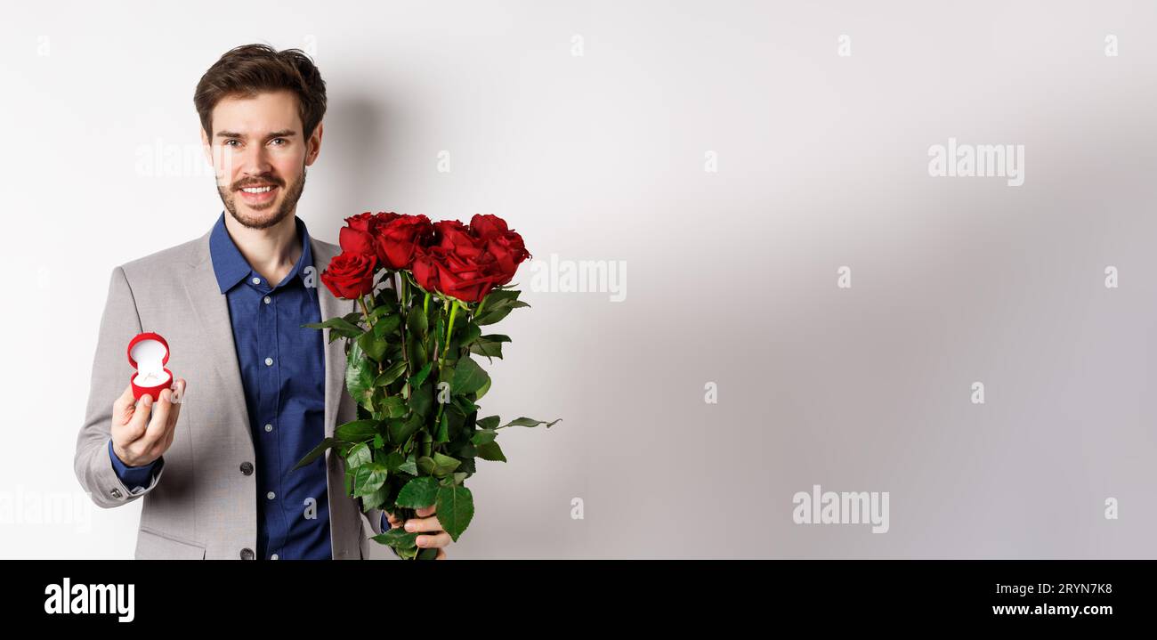 Smiling boyfriend making a marriage proposal, standing with engagement ...