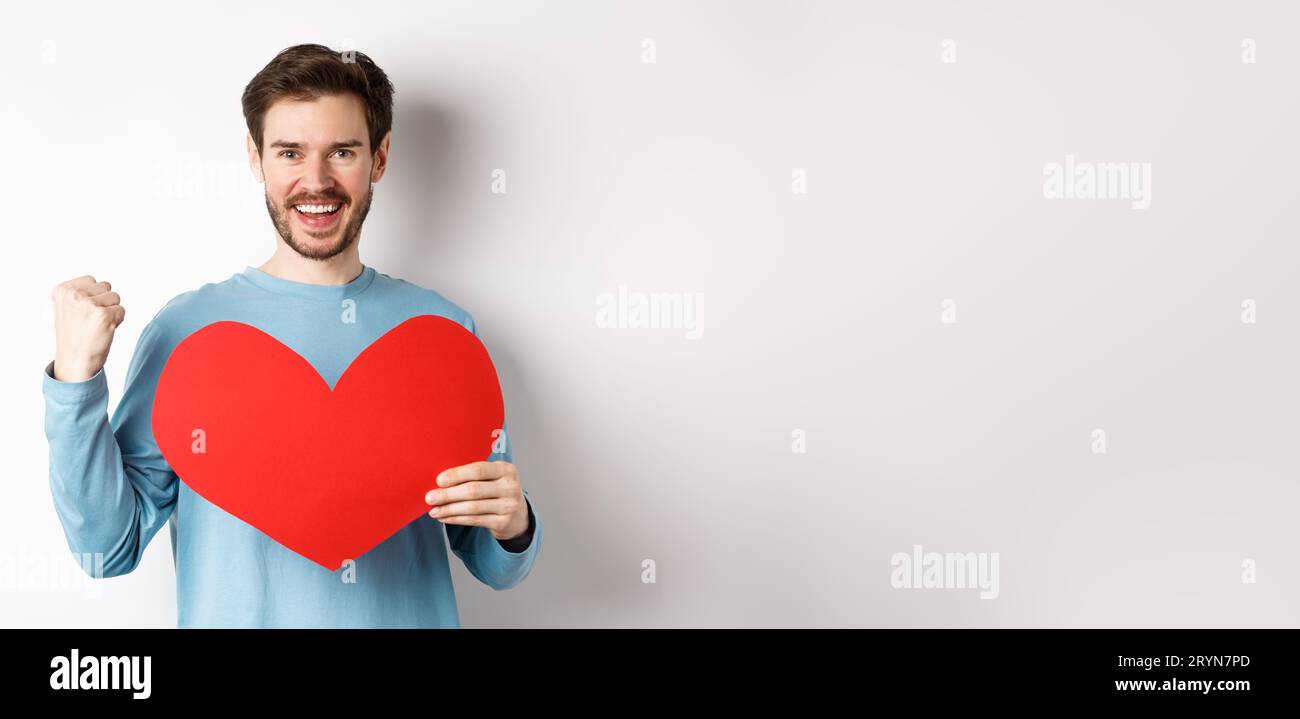 Cheerful man determined to find love on Valentines day, making fist ...